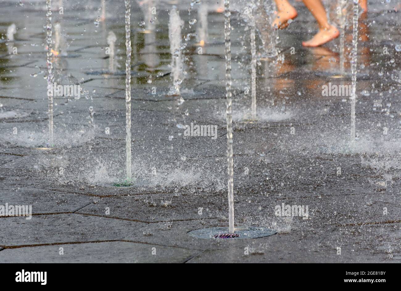 Close-up of water streams from flat fountain in pavement in city Stock ...