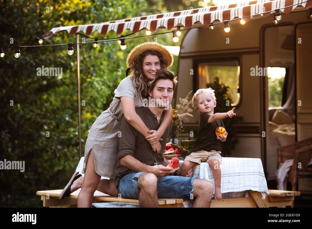 Parents recreating with child outside camper on road trip. Young family ...