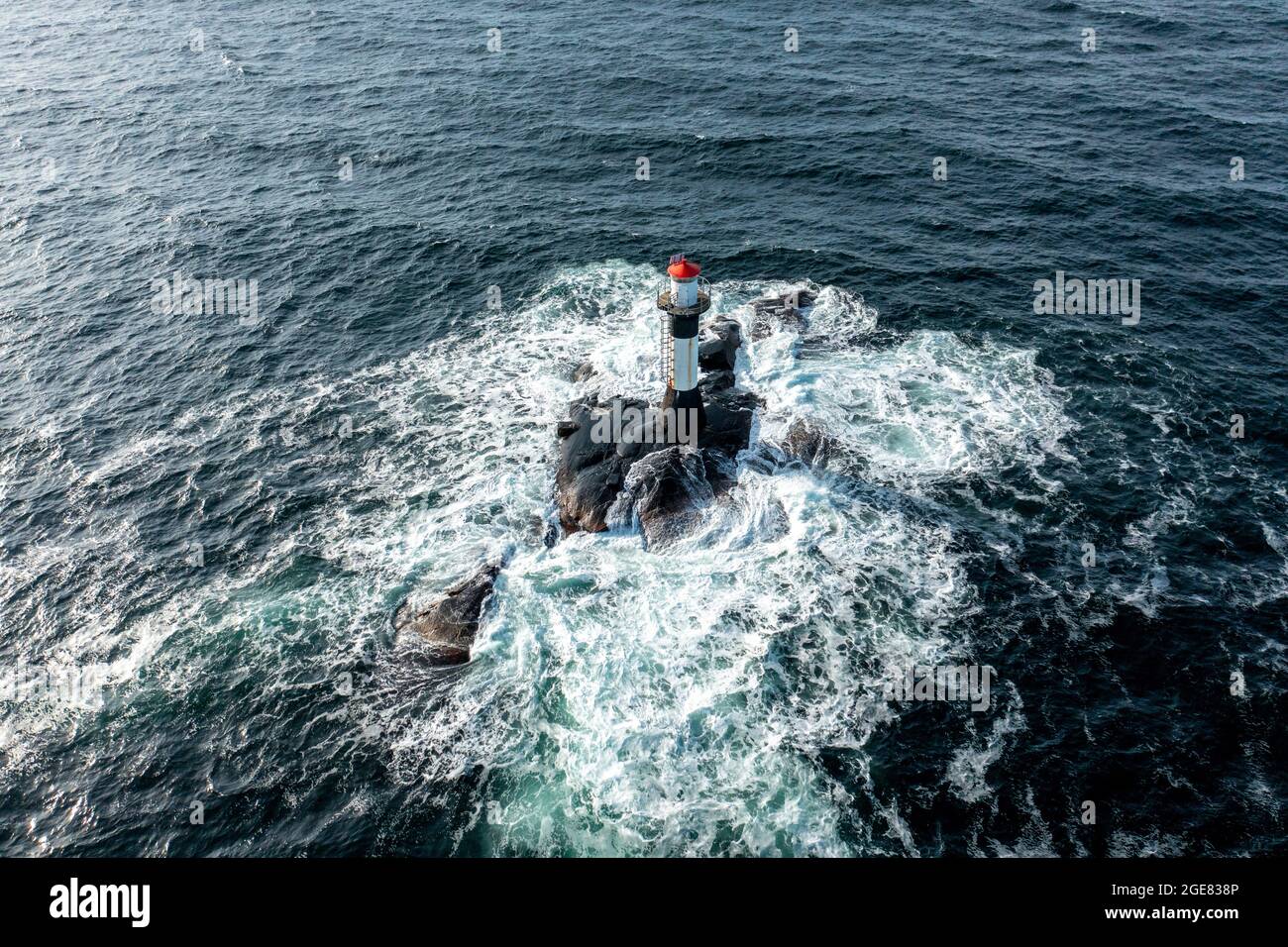 High angle aerial view of Washed lighthouse on a rock in middle of ...