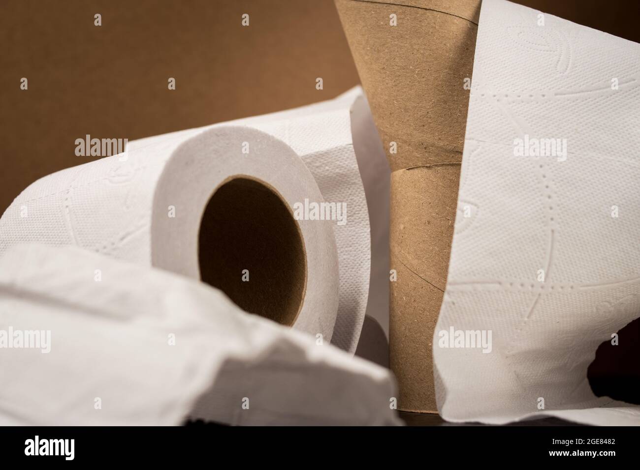 Closeup of unwrapped toilet paper and a stack of empty toilet paper ...