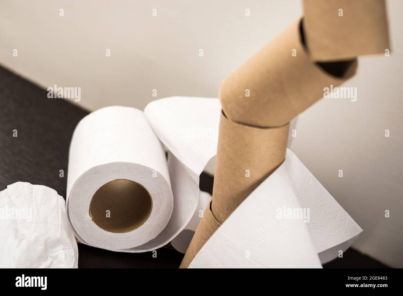 Closeup of unwrapped toilet paper and a stack of empty toilet paper ...