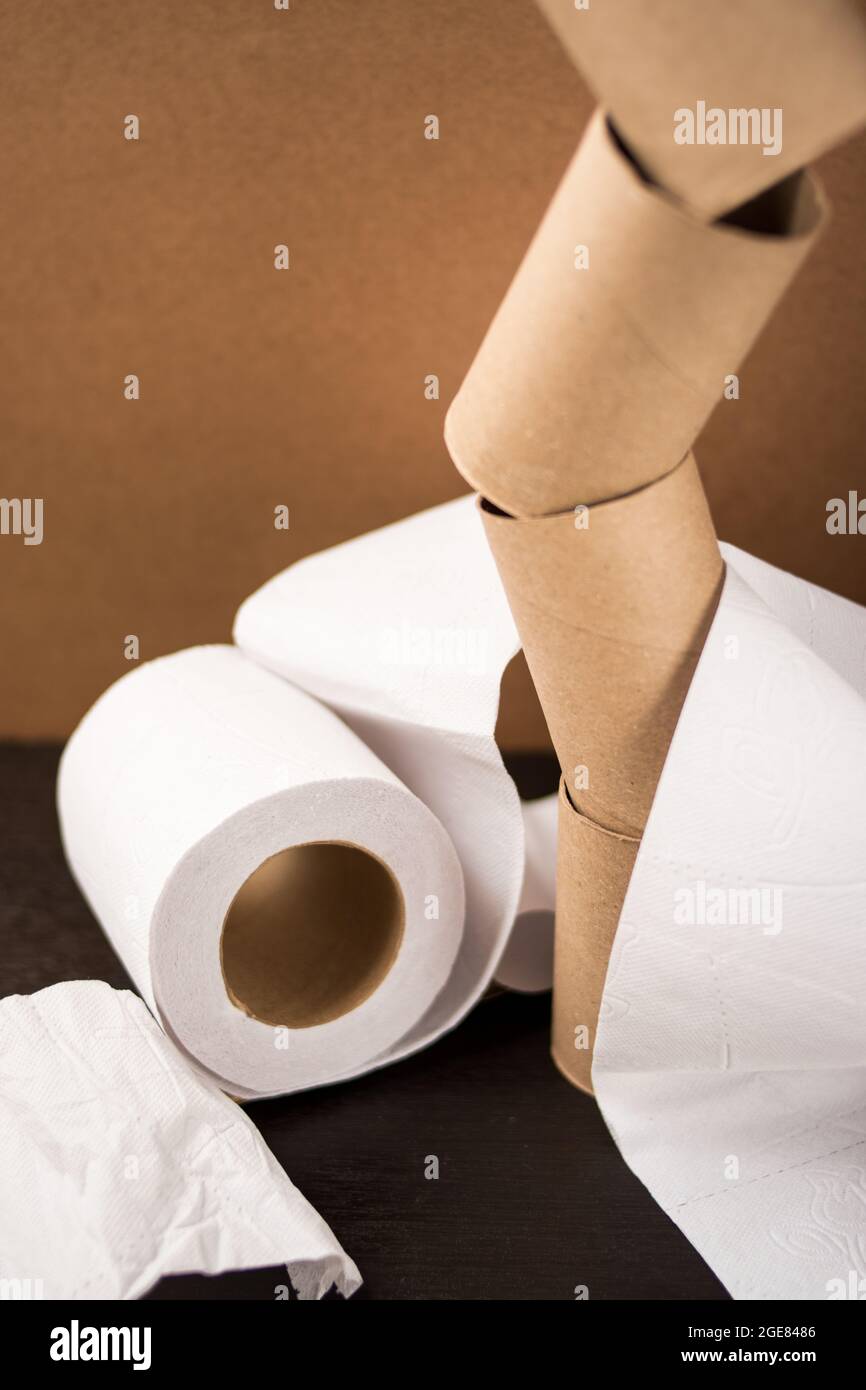 Closeup of unwrapped toilet paper and a stack of empty toilet paper ...