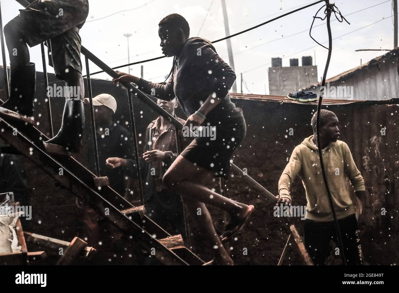Nairobi, Kenya. 17th Aug, 2021. Residents climb to the rooftop to help ...