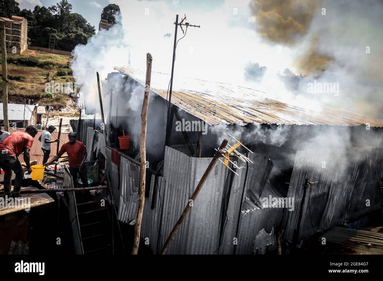 Clouds of smoke are seen coming from a structure, as locals try to put ...
