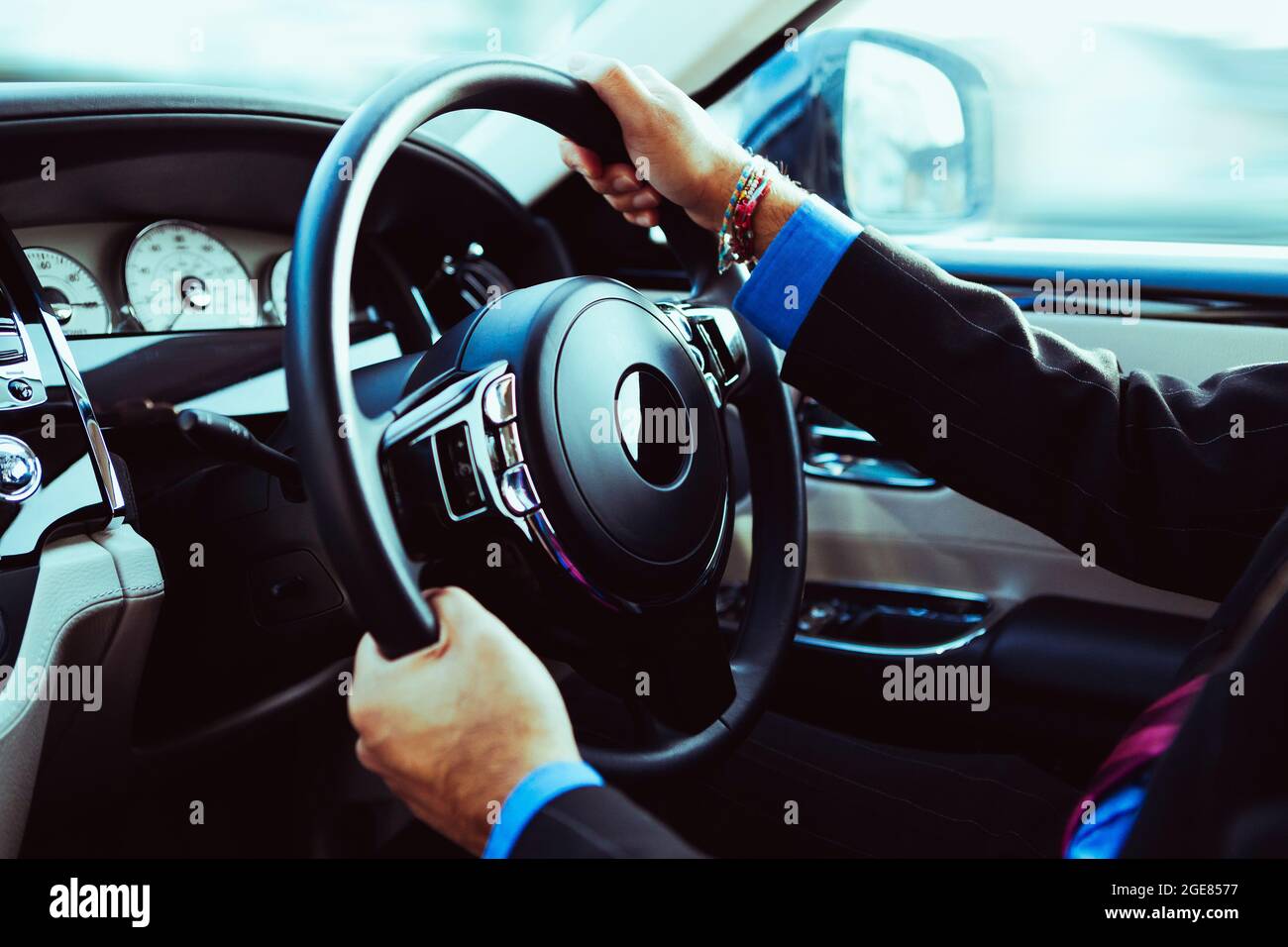 Man wearing suit driving luxury car Stock Photo - Alamy