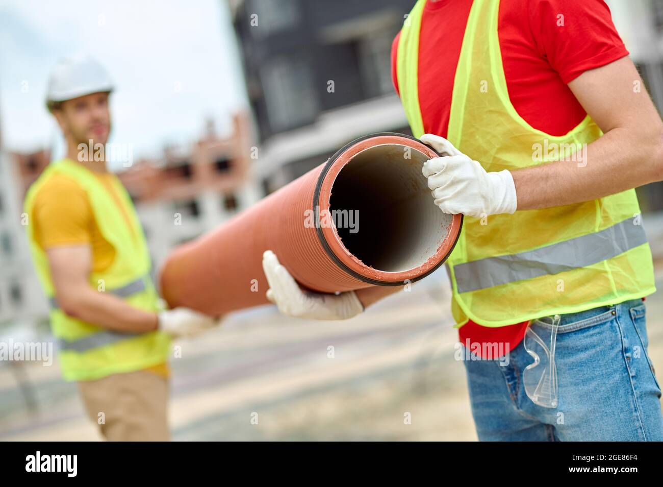 Two workers in cotton gloves holding a corrugated drainage pipe Stock ...