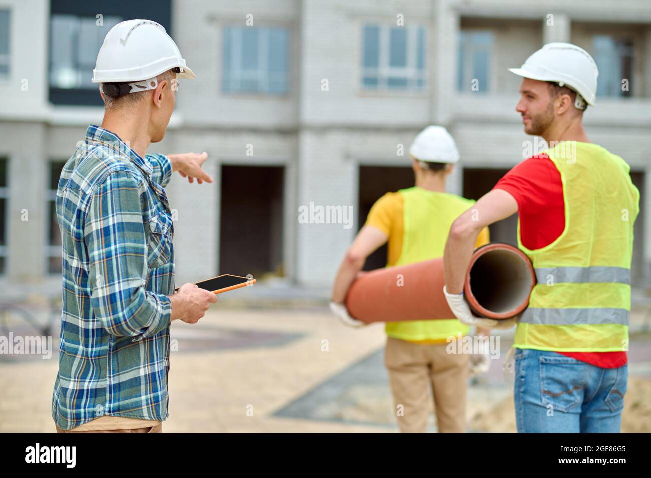 Experienced construction manager supervising young Caucasian male ...