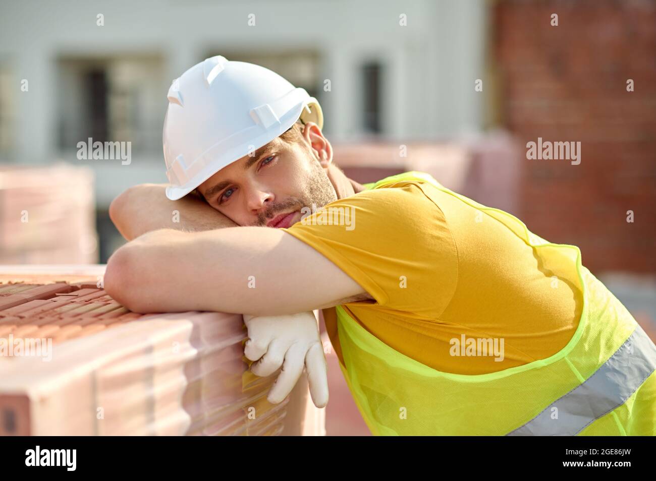 Sad tired builder in a protective helmet resting after hard work Stock ...