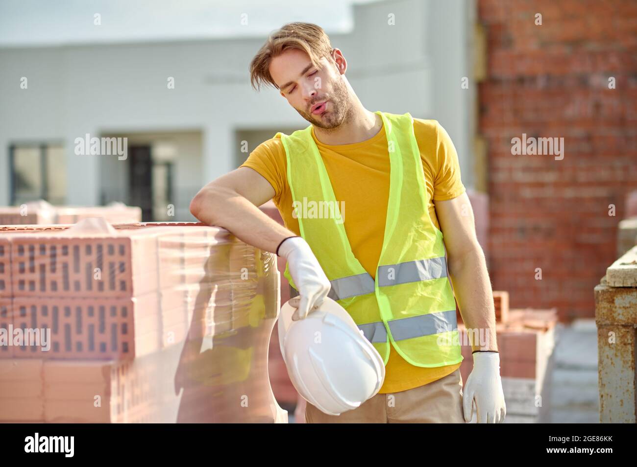 Exhausted young worker taking a break from work Stock Photo - Alamy