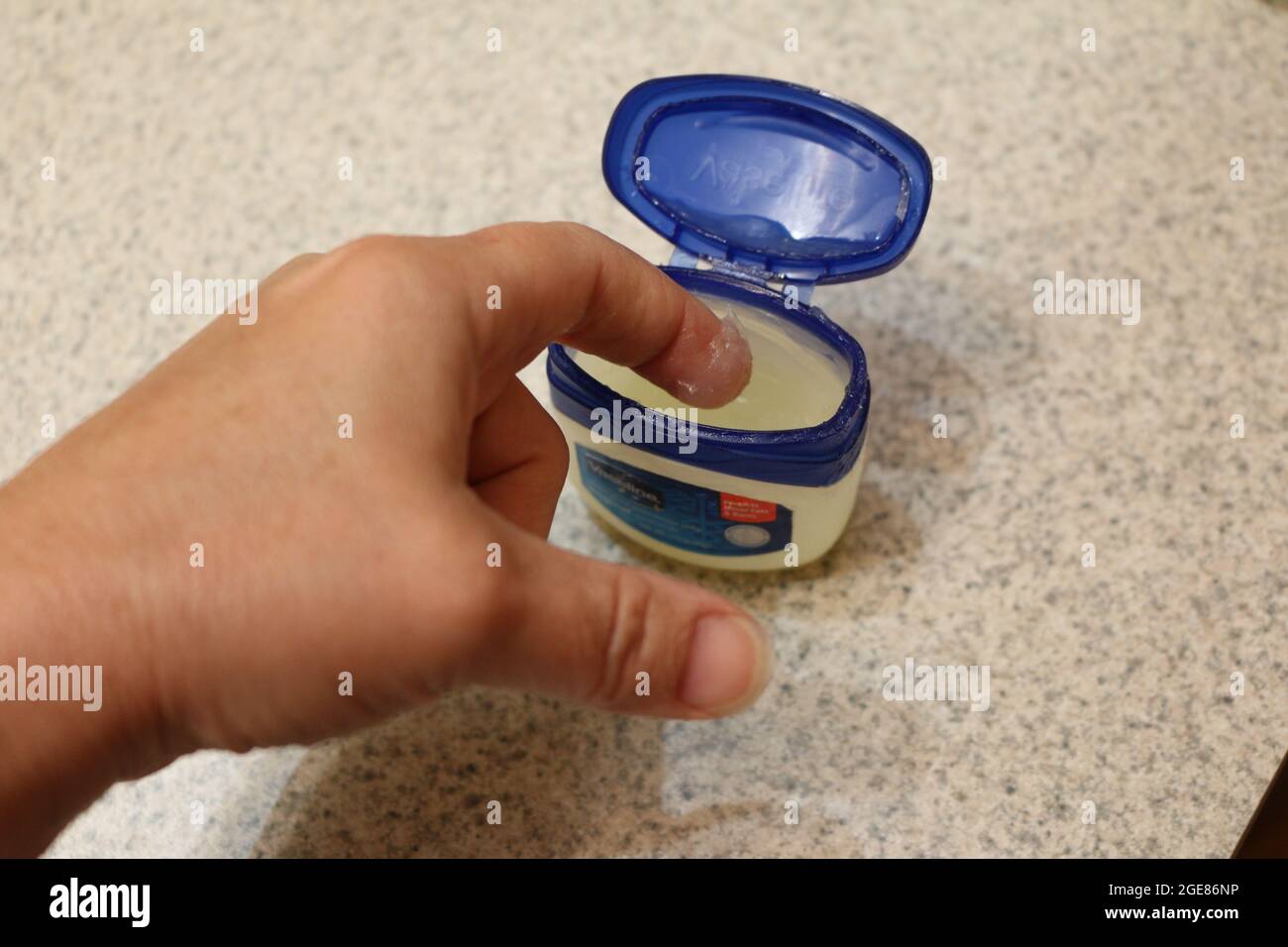 Finger dipping in a Vaseline tub Stock Photo - Alamy