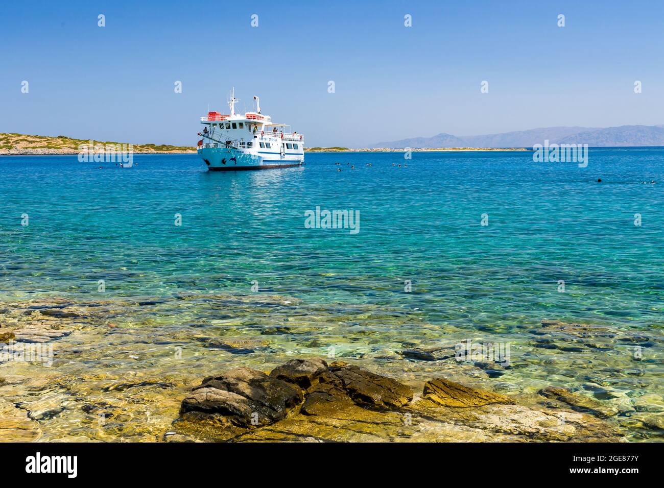 ELOUNDA, CRETE - 16 JULY 2021: Groups of tourists swim around and ...