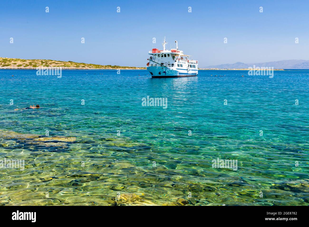 ELOUNDA, CRETE - 16 JULY 2021: Groups of tourists swim around and ...