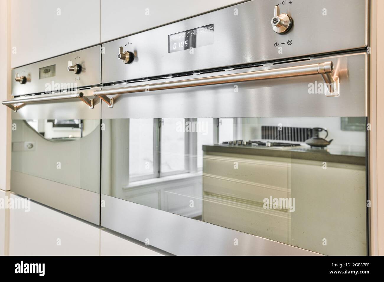 Closeup shot of a silver oven in the kitchen with the reflection of the ...