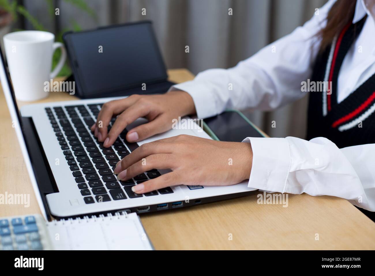 Schoolgirl's hands typing on a laptop Stock Photo - Alamy