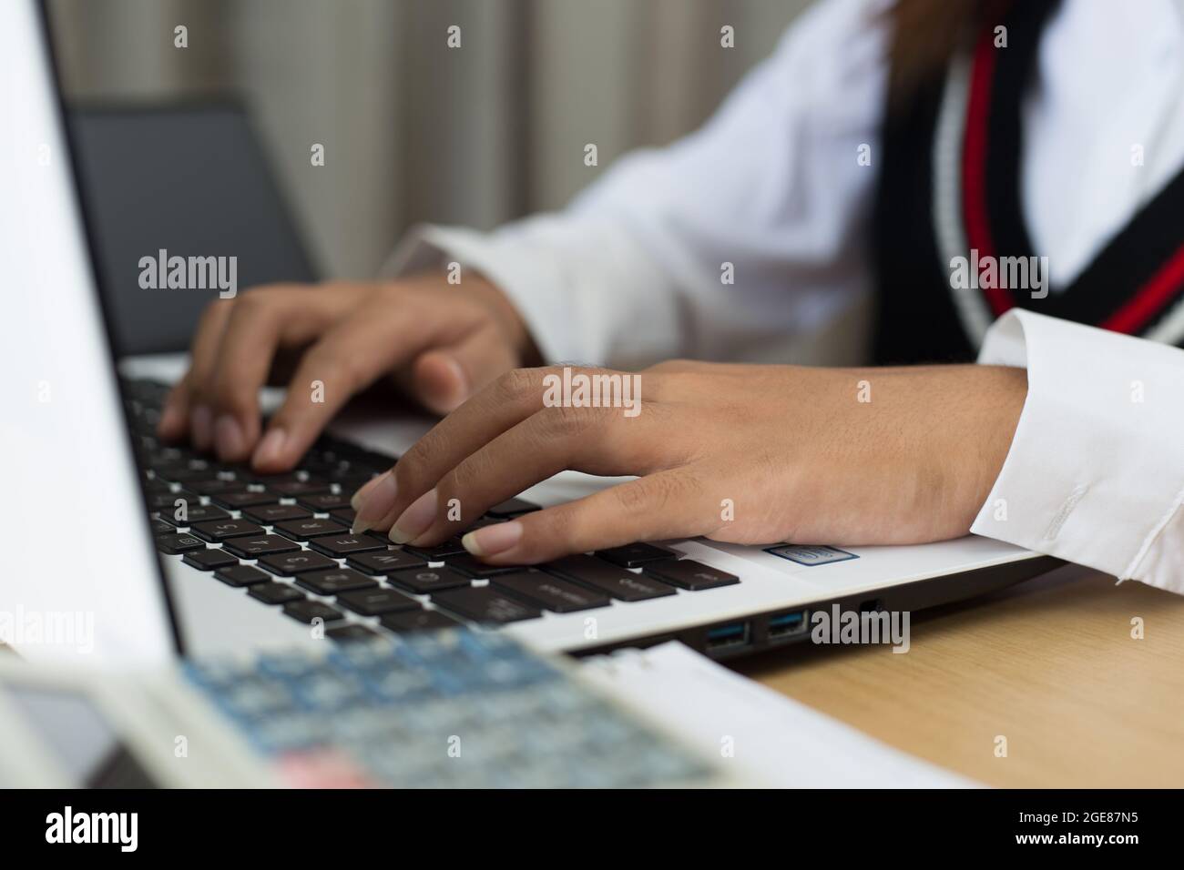 Schoolgirl's hands typing on a laptop Stock Photo - Alamy