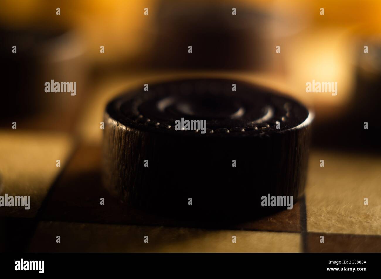 Closeup shot of a black checkers piece on the board Stock Photo - Alamy