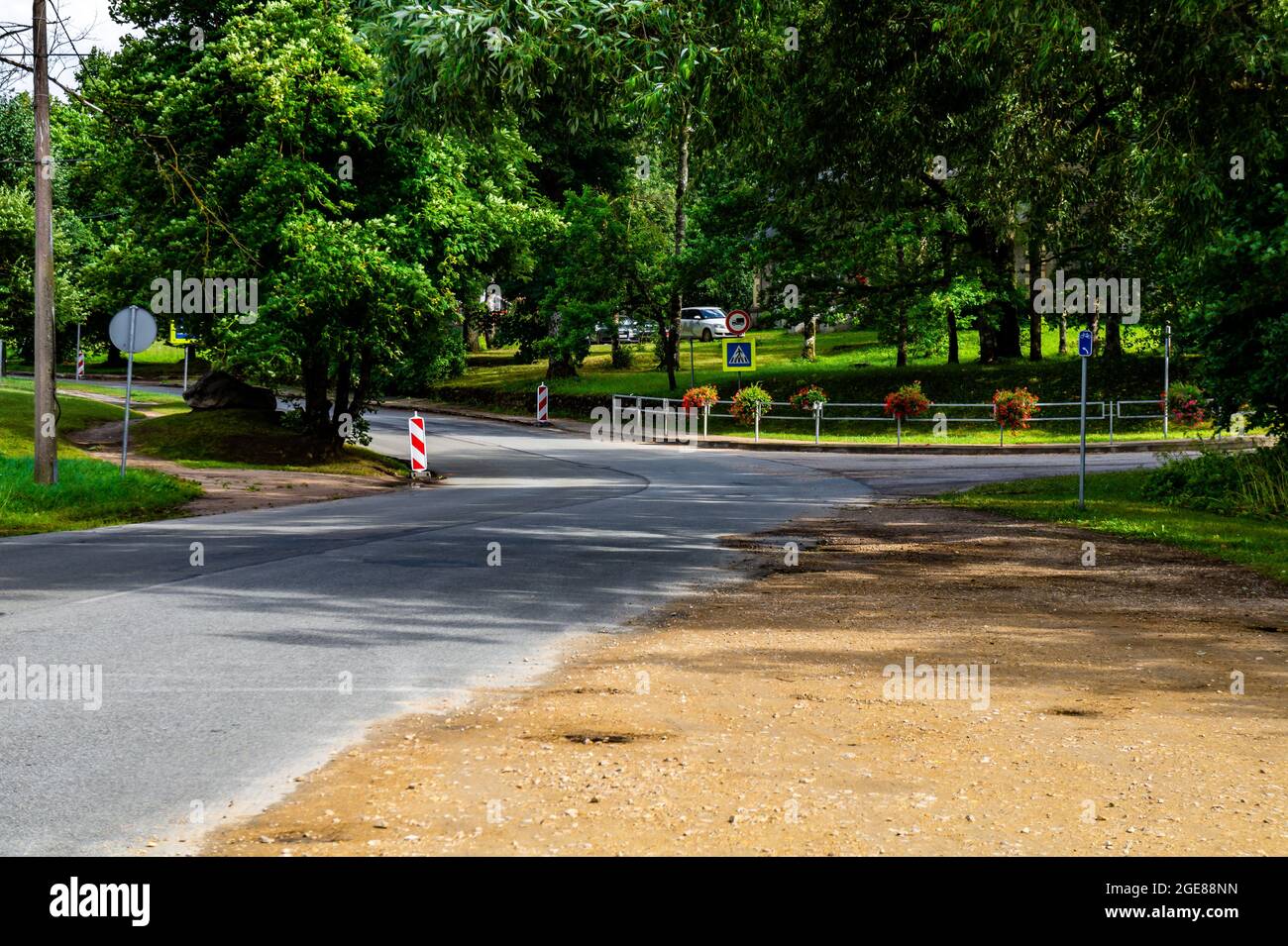 Closeup shot of a park landscape with a walking path and green trees on ...