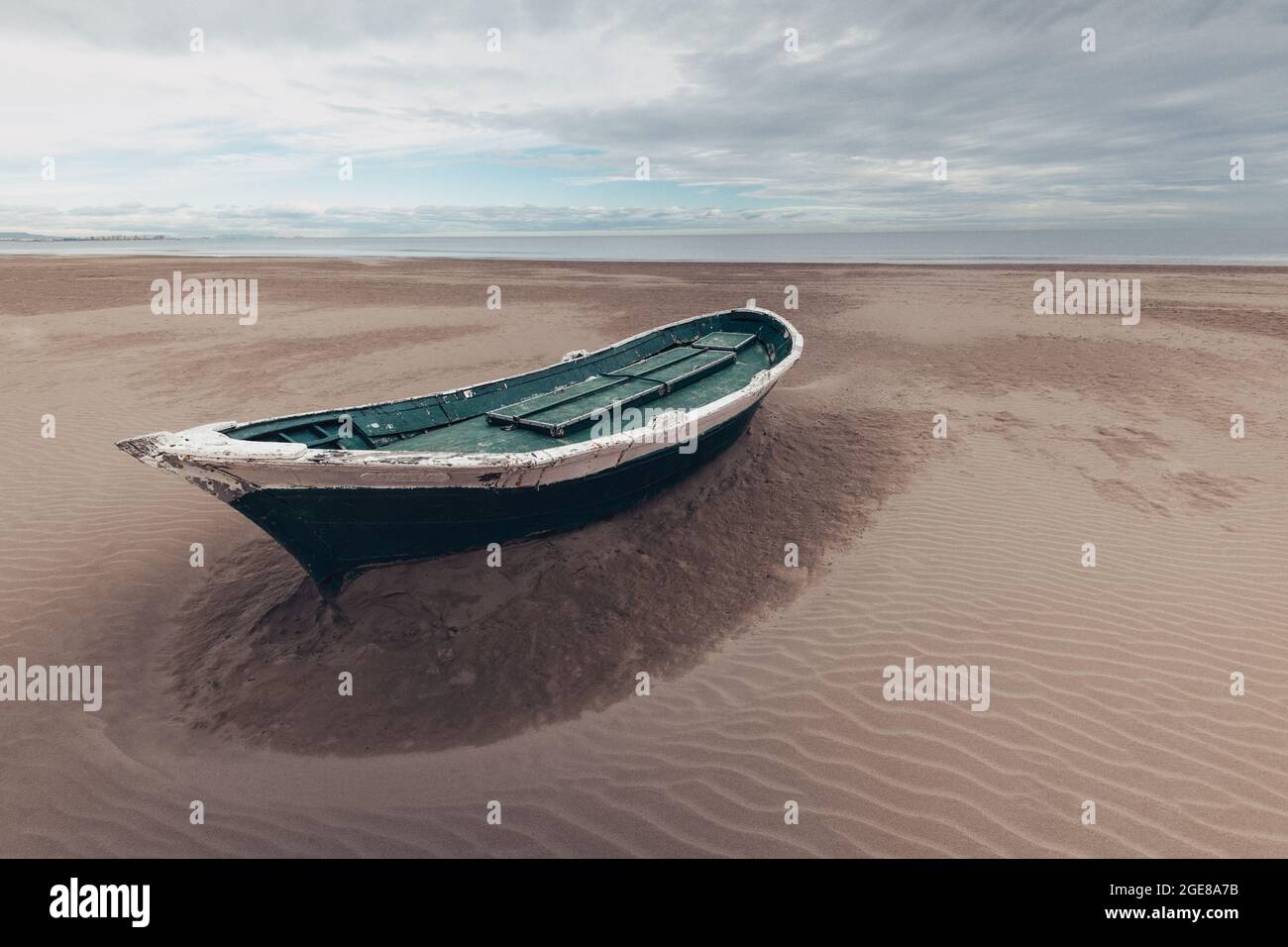 Green wooden boat on a sand seashore Stock Photo - Alamy