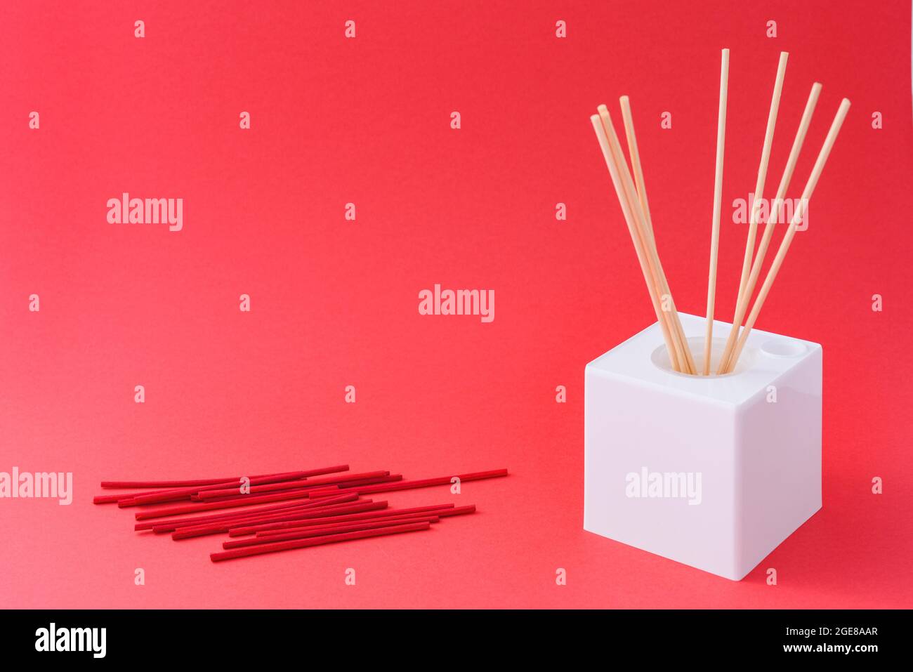 White cube box with incense sticks on a red background Stock Photo - Alamy
