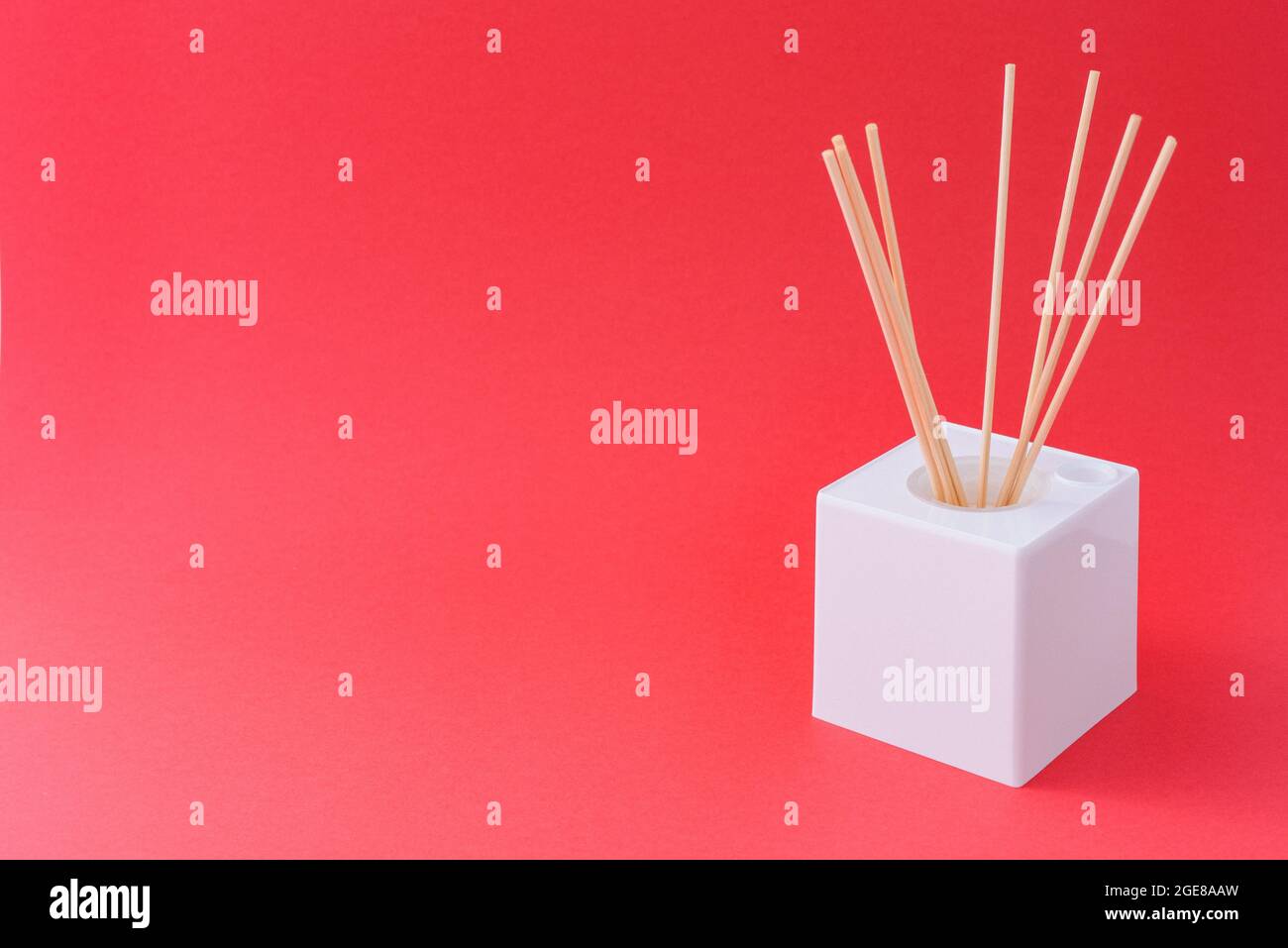 White cube box with incense sticks on a red background Stock Photo - Alamy