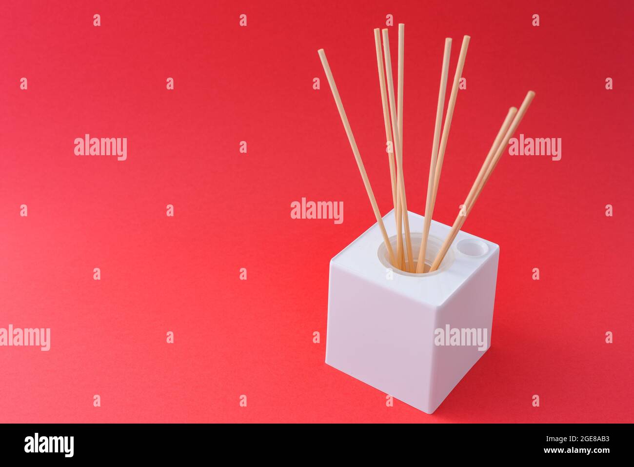 White cube box with incense sticks on a red background Stock Photo - Alamy