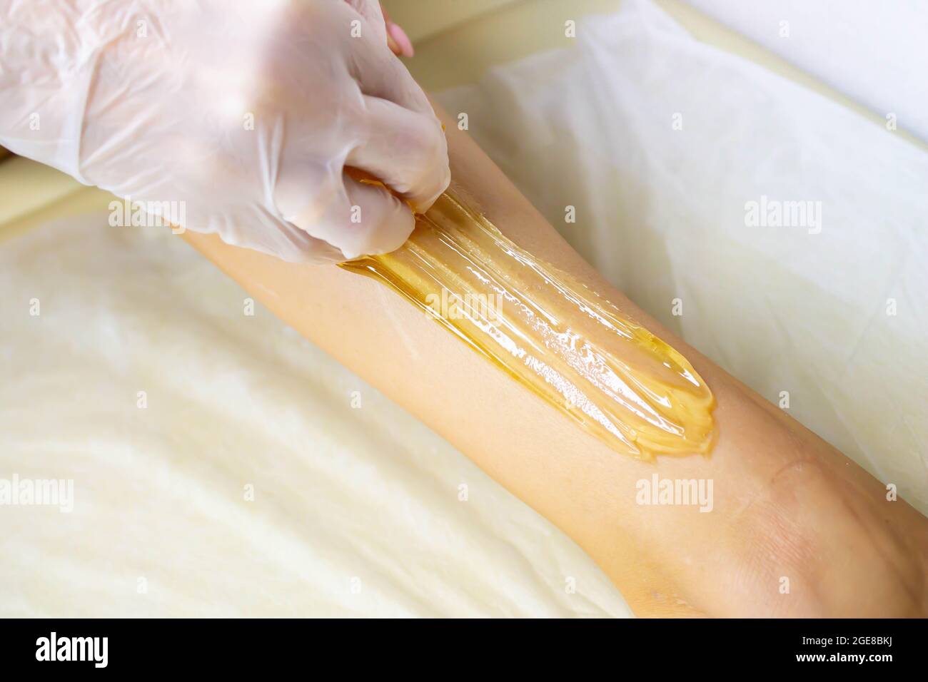 Applying sugar paste to remove hair. The process of removing hair from ...