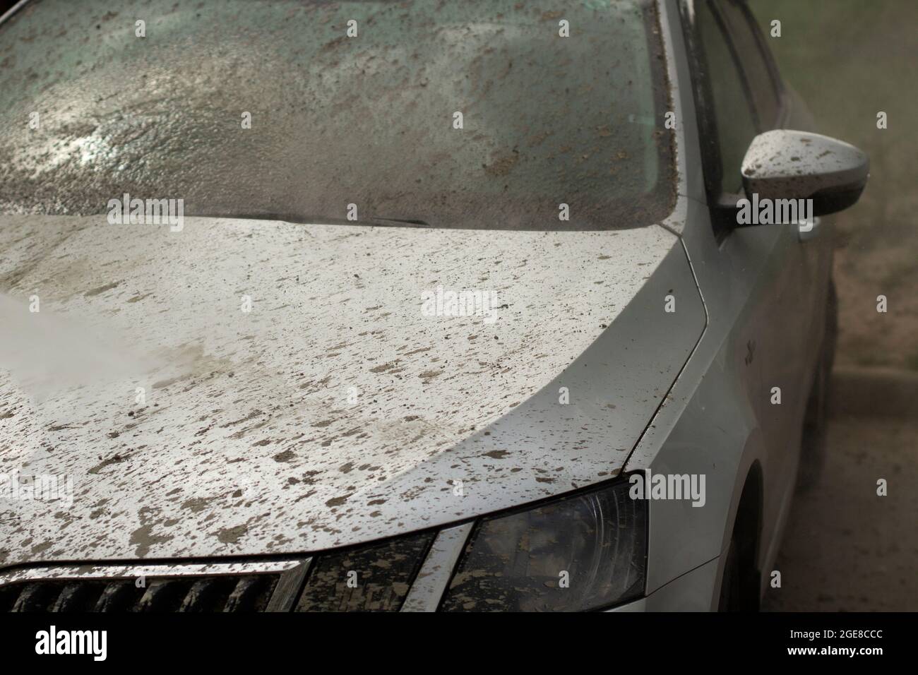 Dirty car on the street. Car wash. Pressurized water washes away dirt ...