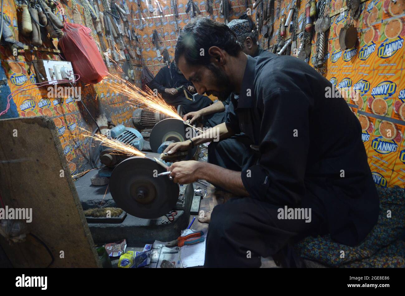 Peshawar, Pakistan. 17th Aug, 2021. Pakistani workers sharpen knives at ...