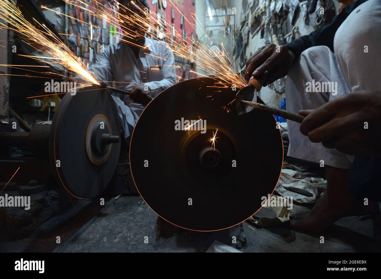 Peshawar, Pakistan. 17th Aug, 2021. Pakistani workers sharpen knives at ...