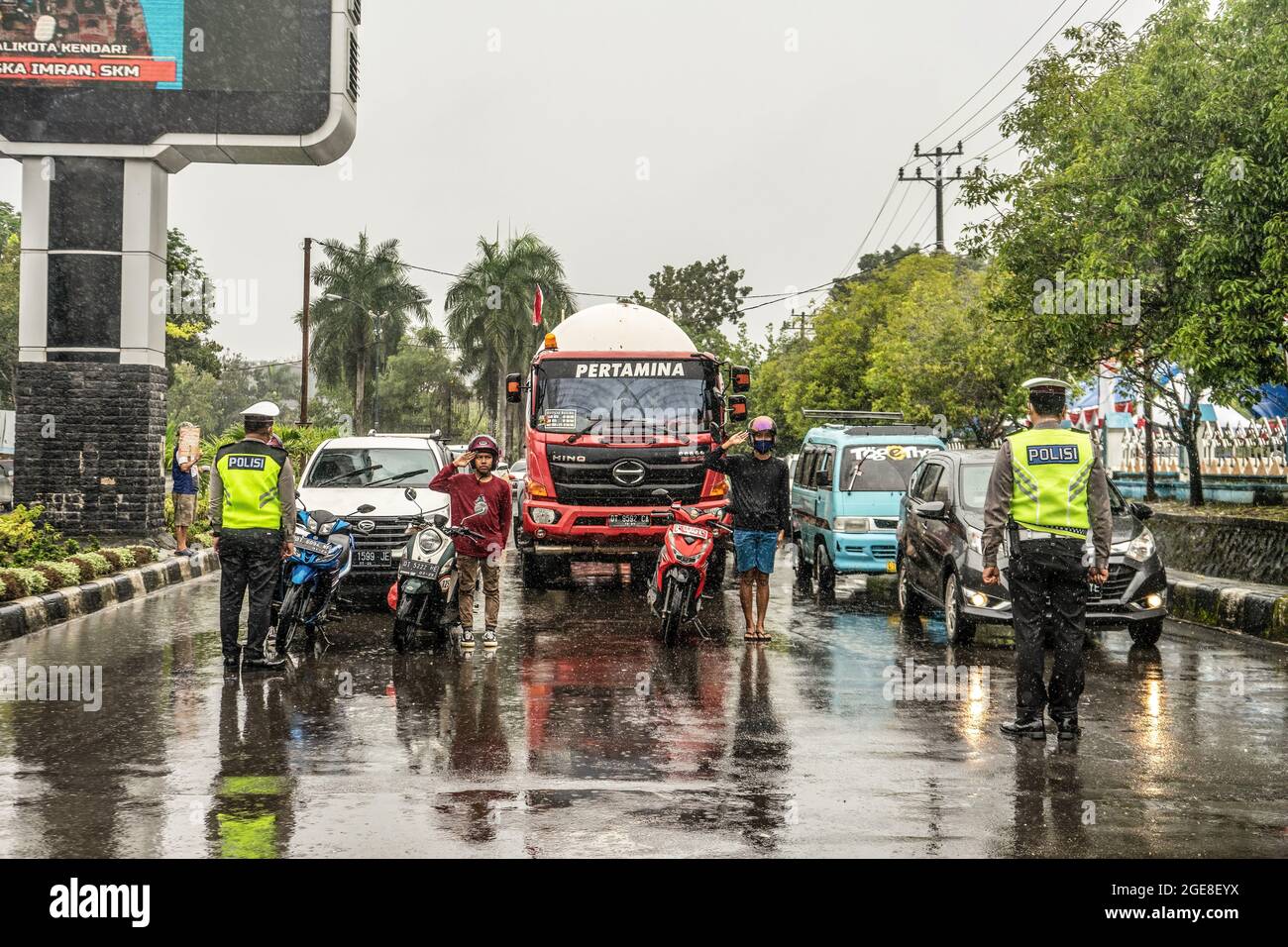 Kendari, Indonesia. 17th Aug, 2021. Police officers stand alert with ...