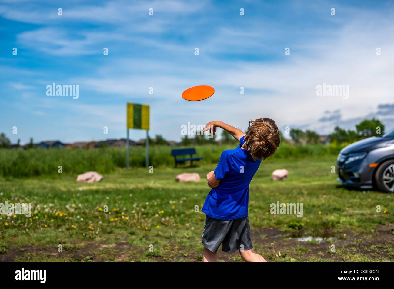 Caucasian child playing disc golf and making the first toss Stock Photo ...