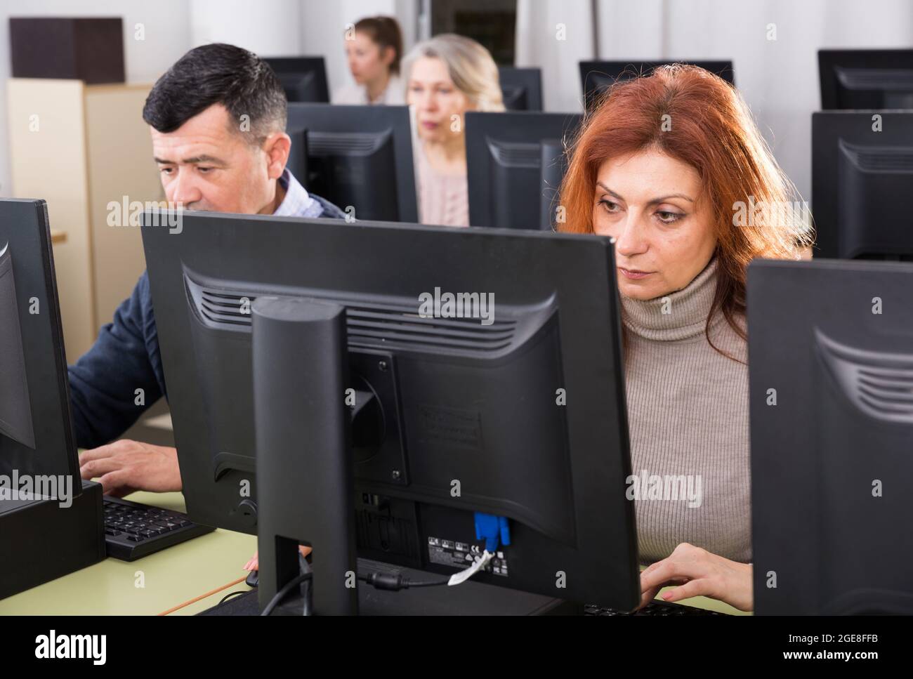 Middle aged woman taking computer lessons Stock Photo - Alamy