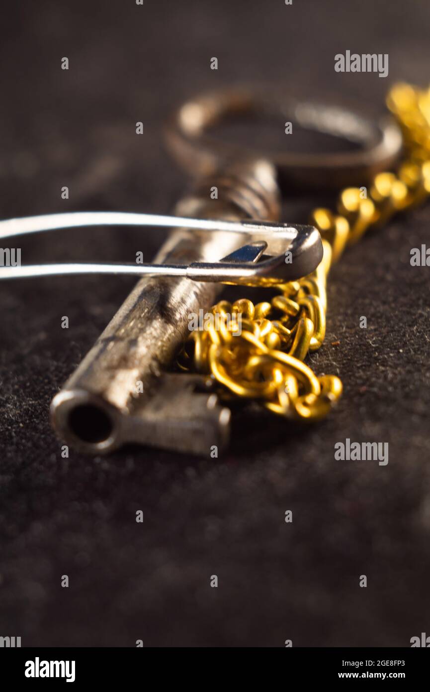 Old key with a golden chain on a textured surface Stock Photo - Alamy