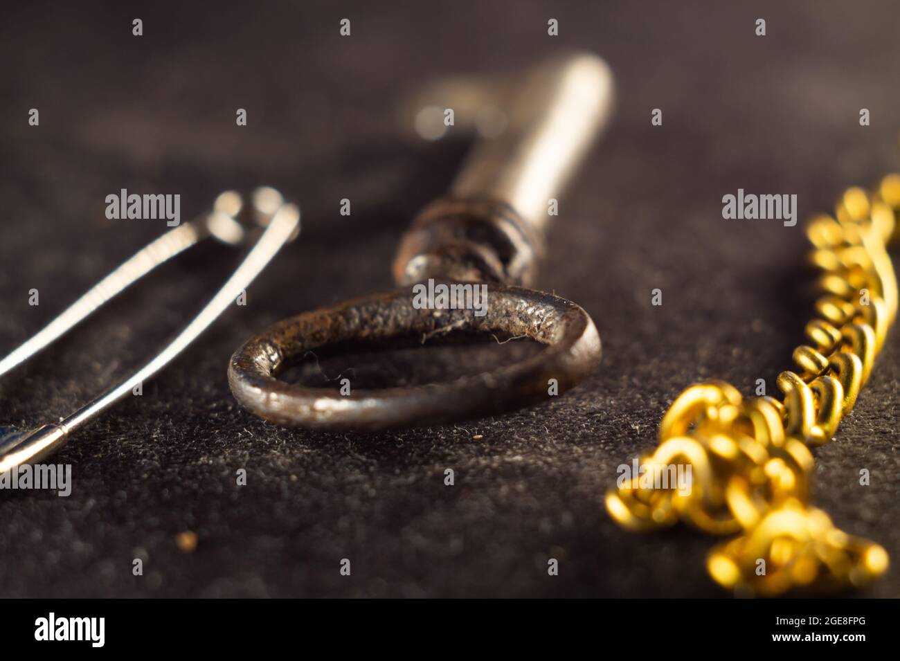 Old key with a golden chain on a textured surface Stock Photo - Alamy