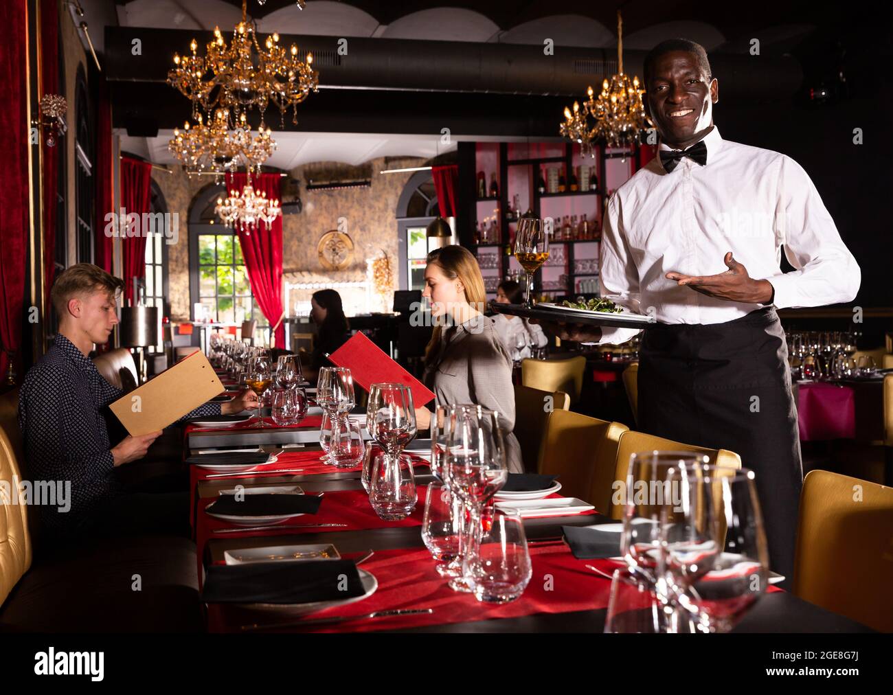 Waiter demonstrating tray of dish Stock Photo - Alamy