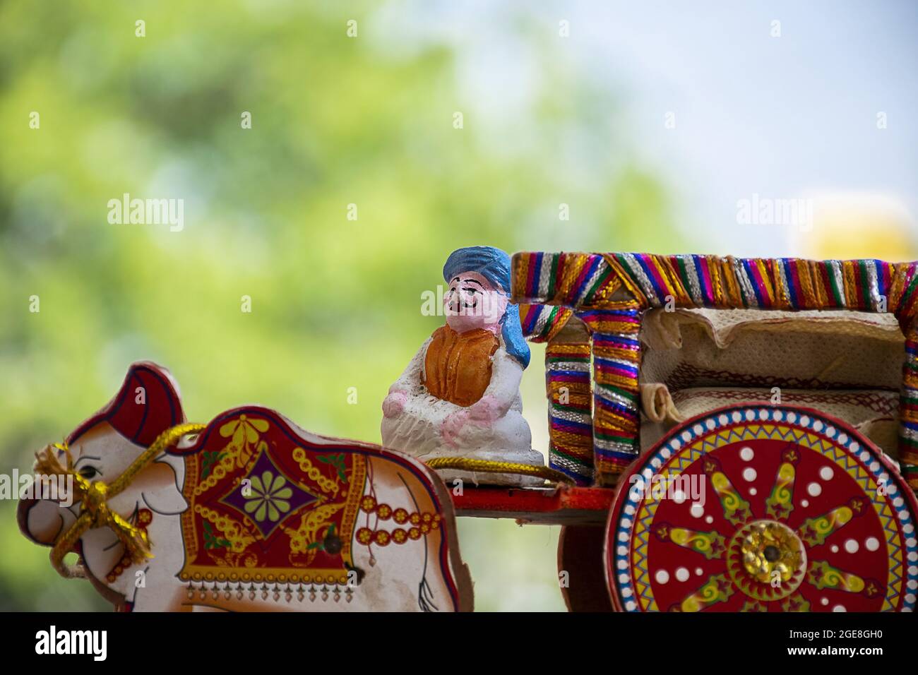 Traditional Indian wooden farmer sitting on a bull cart in rice grains ...