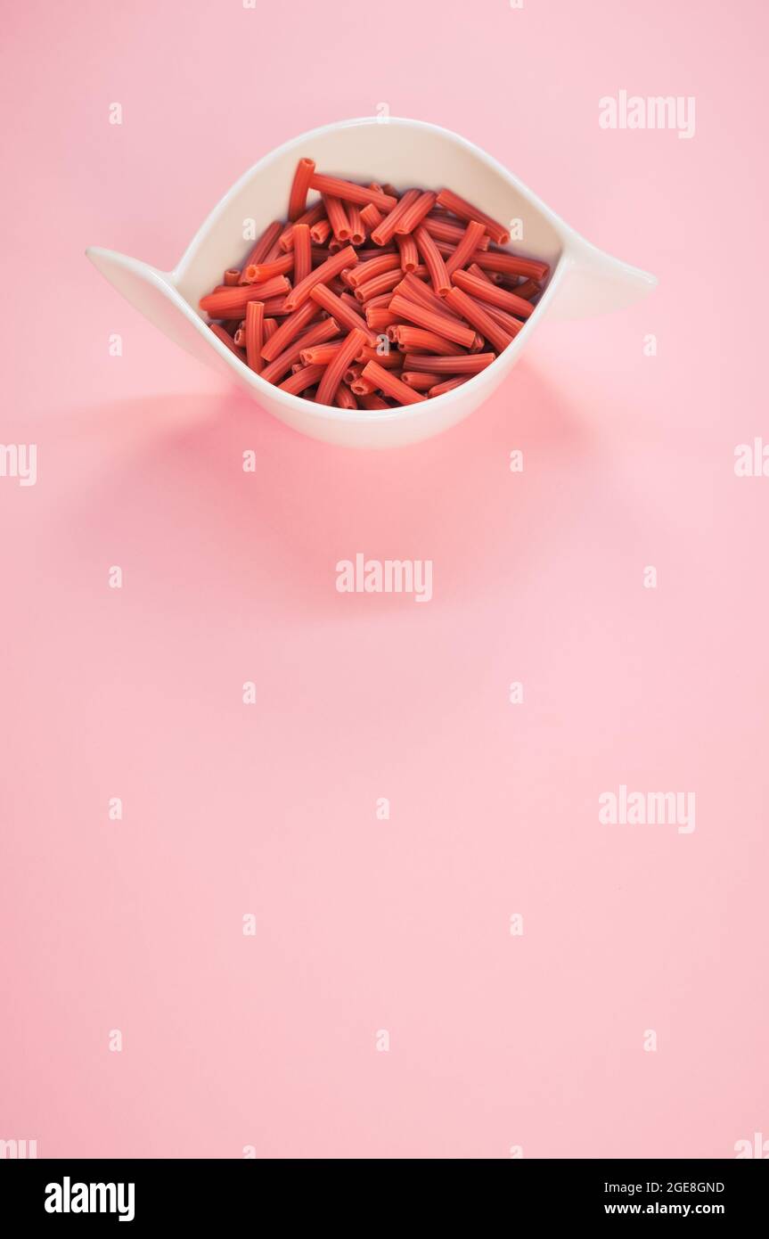 Bowl of dry macaroni pasta isolated on a pink background with free ...