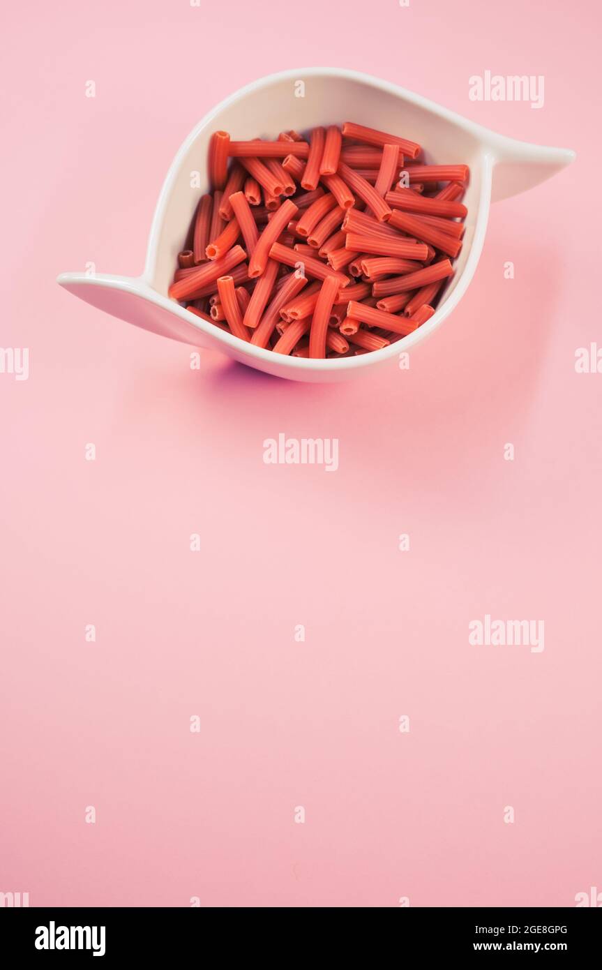 Bowl of dry macaroni pasta isolated on a pink background with free ...