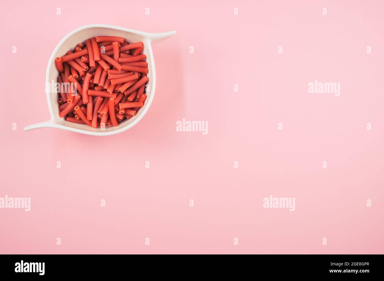 Bowl of dry macaroni pasta isolated on a pink background with free ...
