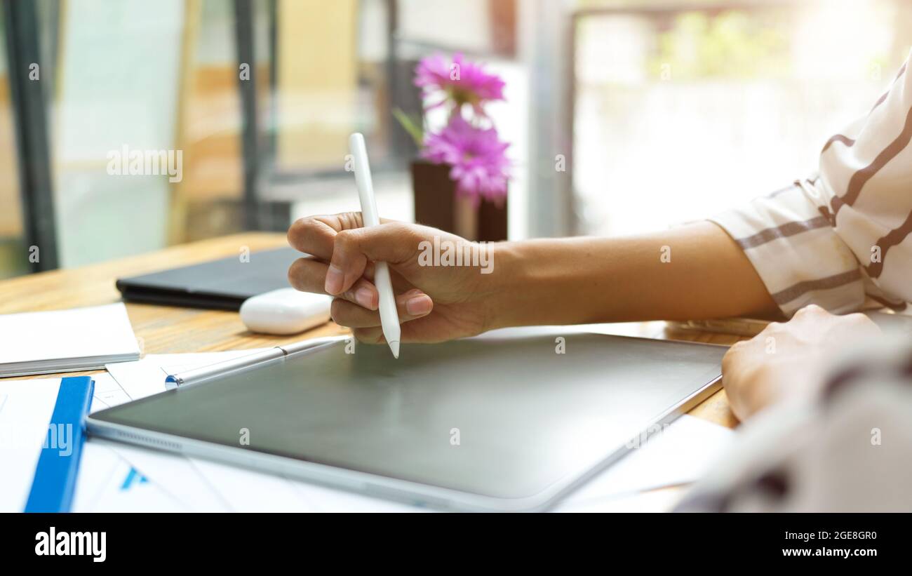 Close up, female hand using stylus pen for drawing on graphic portable ...