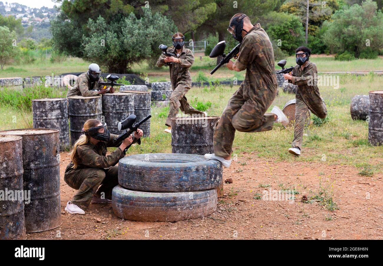 Two active opposing teams with guns playing paintball Stock Photo - Alamy