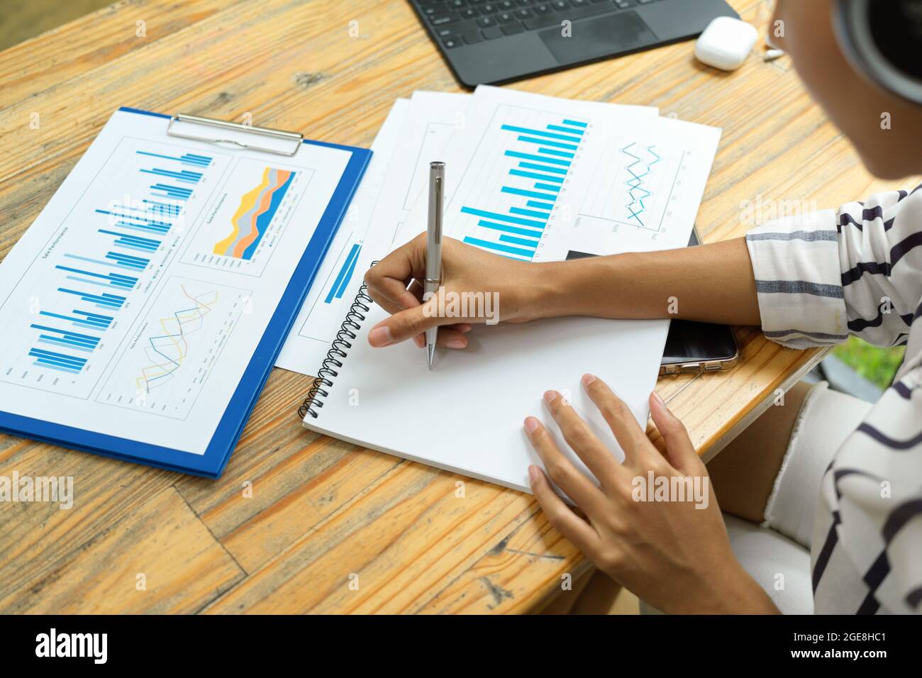 Close up, female financial worker taking notes about business finance ...