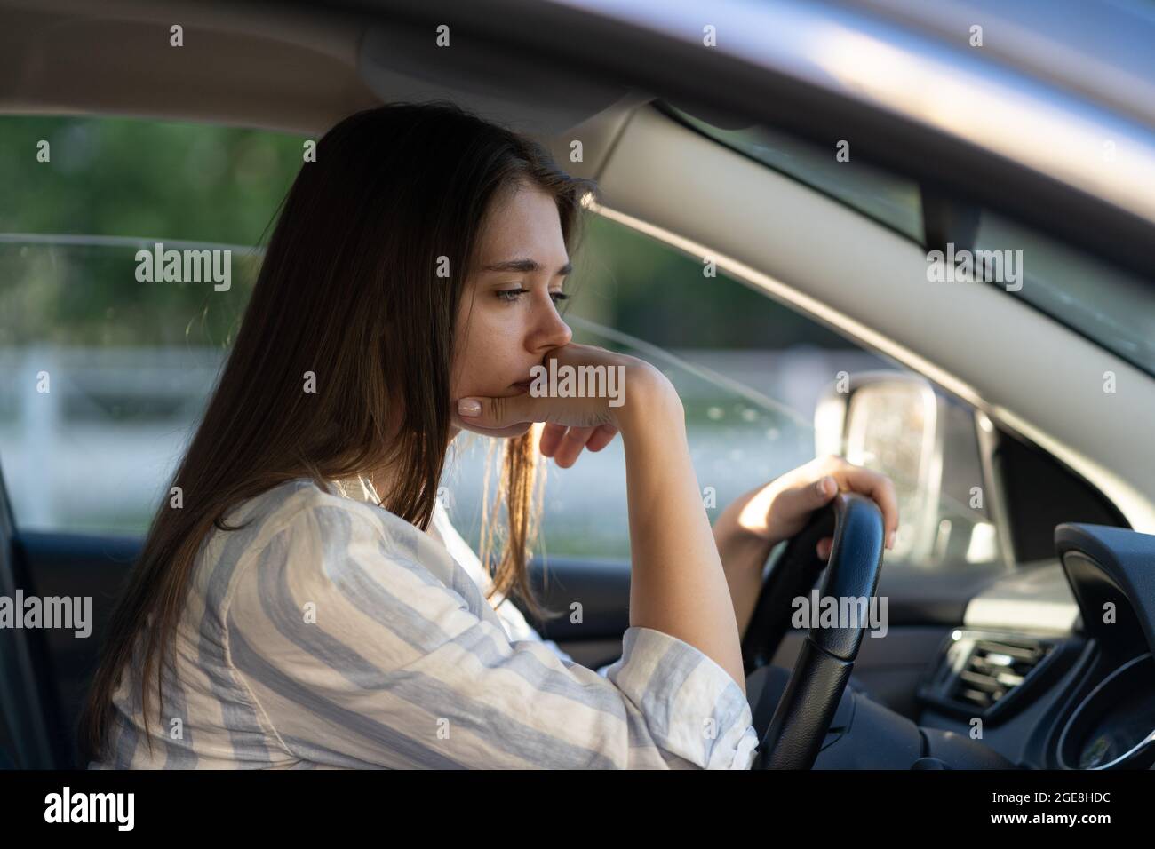 Drunk girl driving car. Unhappy tired young female in vehicle suffering ...