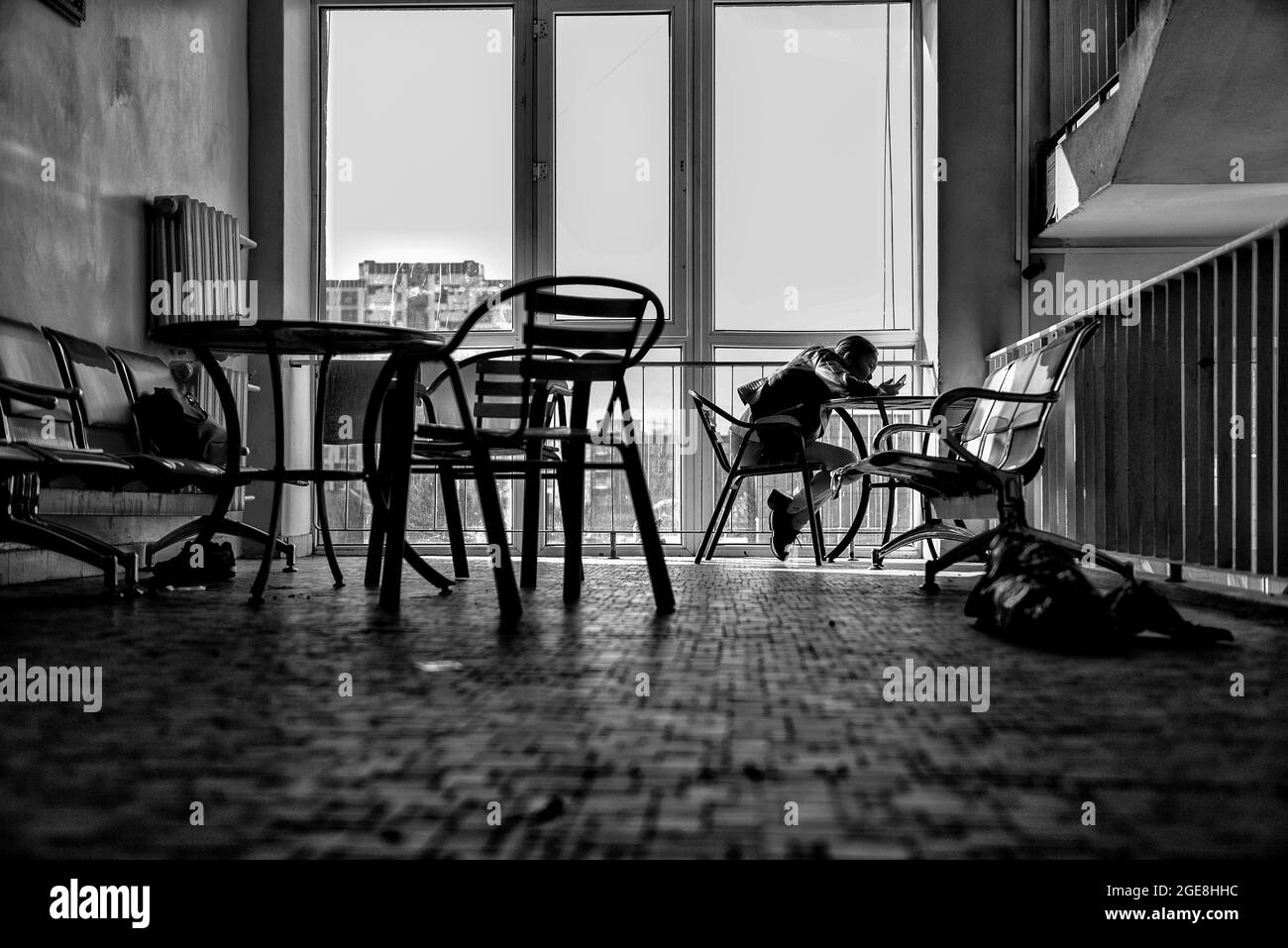 Grayscale shot of the interior of a cafe with simple chairs and tables ...