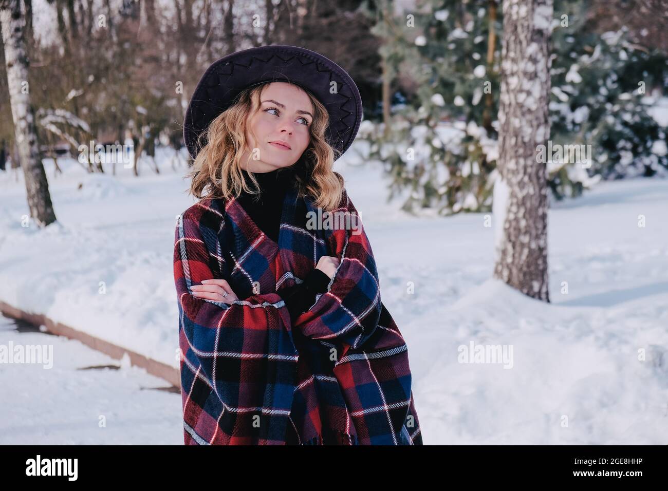 Young woman enjoying winter weather in the snow park. Cold weather ...