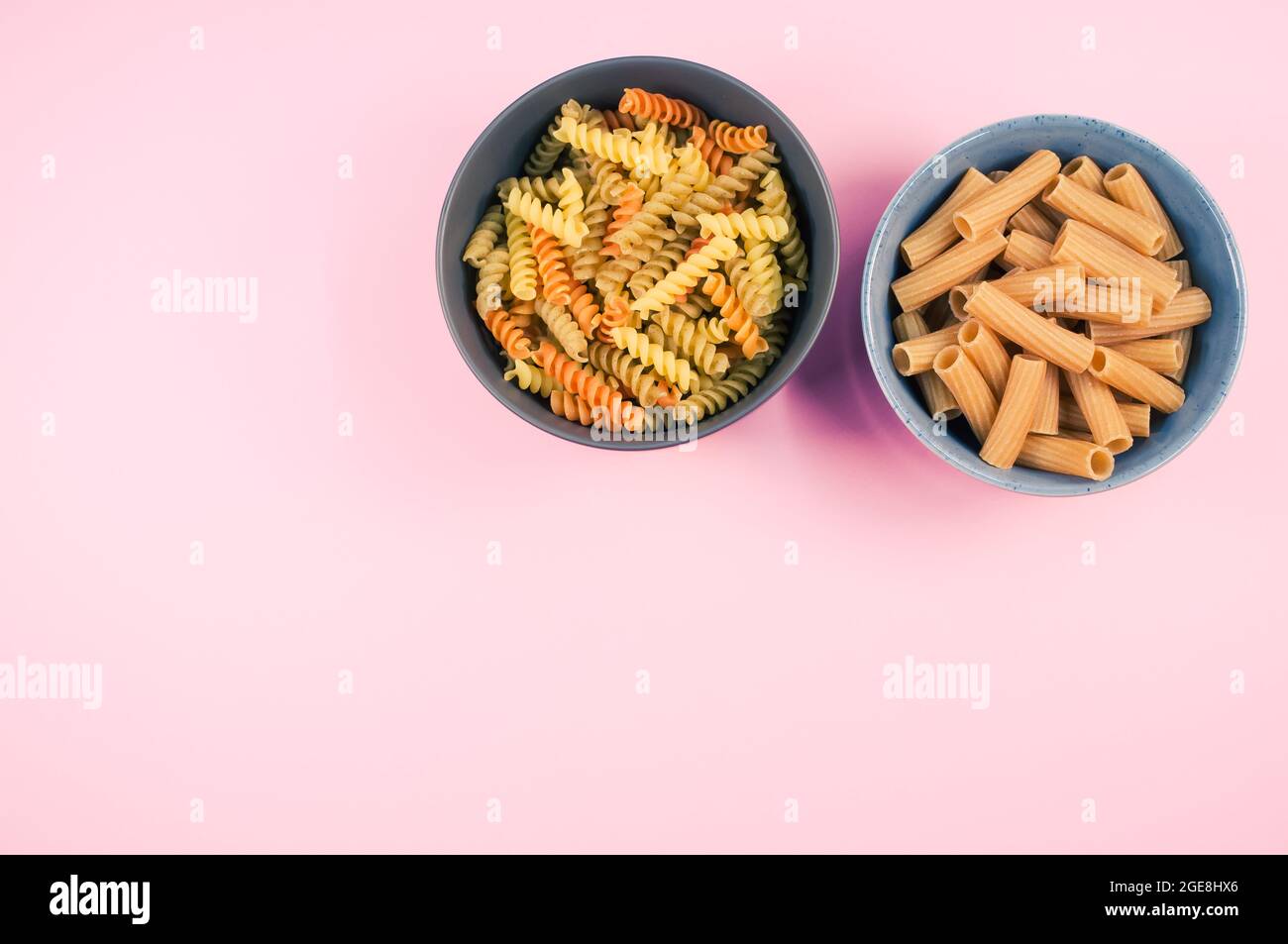 Top view of tri-color rotini and rigatoni pasta on a bowl isolated on ...