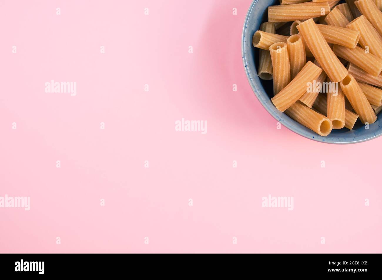 Top view of rigatoni pasta on a bowl isolated on pink background Stock ...