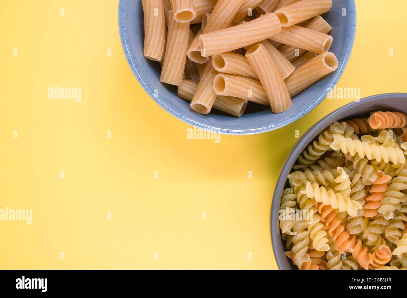 Top view of tri-color rotini and rigatoni pasta on a bowl isolated on ...