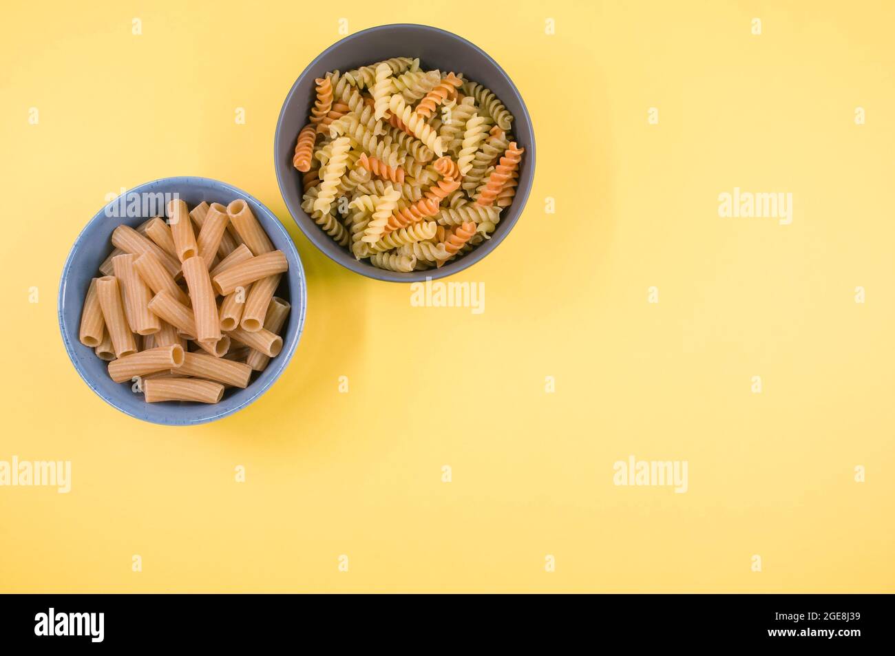 Top view of tri-color rotini and rigatoni pasta on a bowl isolated on ...