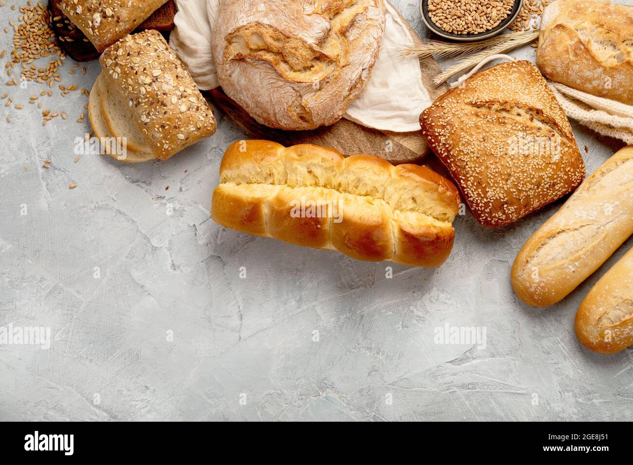Various types of fresh baked bread on light gray background. Top view ...